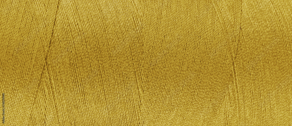Texture of yellow color threads in spool close up, macro. Wide banner ...