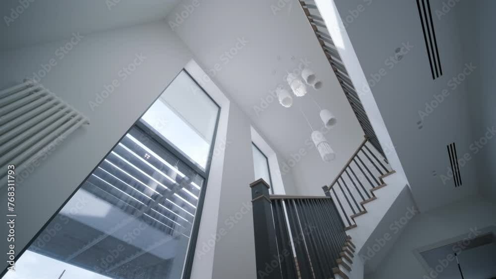 A high ceiling atrium with a large skylight floods the modern staircase ...