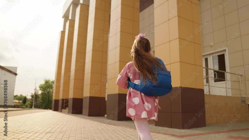 Happy cute little girl with backpack and book running to elementary ...