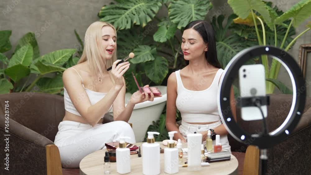 Two beautiful content creator making natural beauty and cosmetic tutorial on green plant leave ...