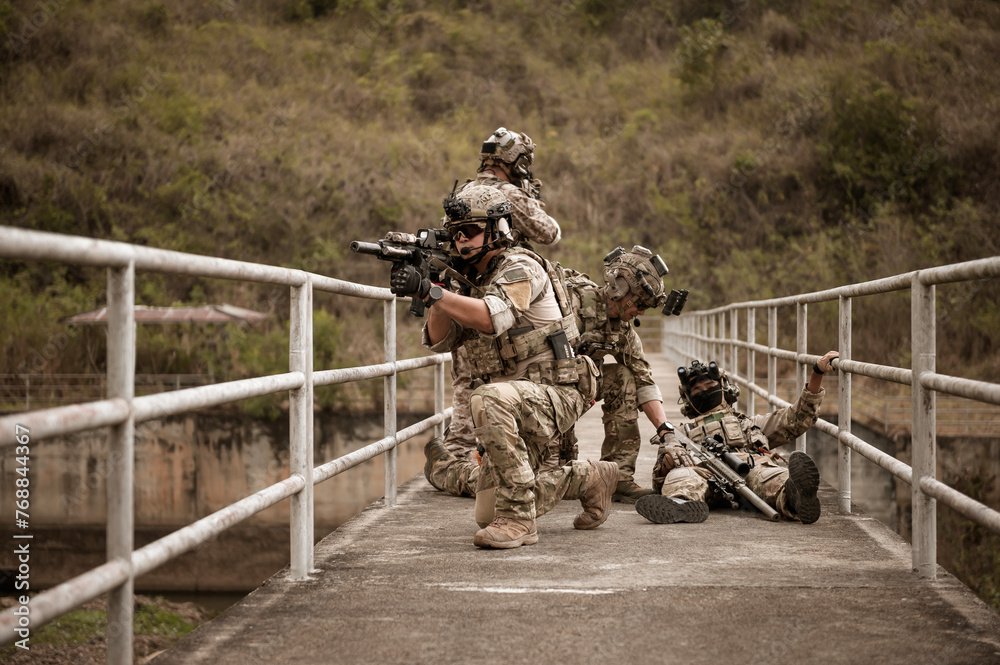 Soldiers in camouflage uniforms aiming with their rifles.ready to fire ...