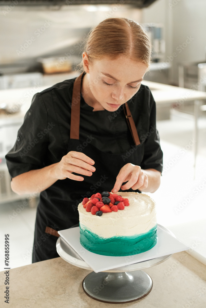 Vertical photo of a bright production in a confectionery shop. A young ...