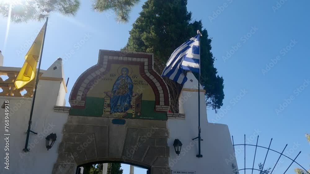 Entrance gate with fluttering Greek flag at monastery in ...