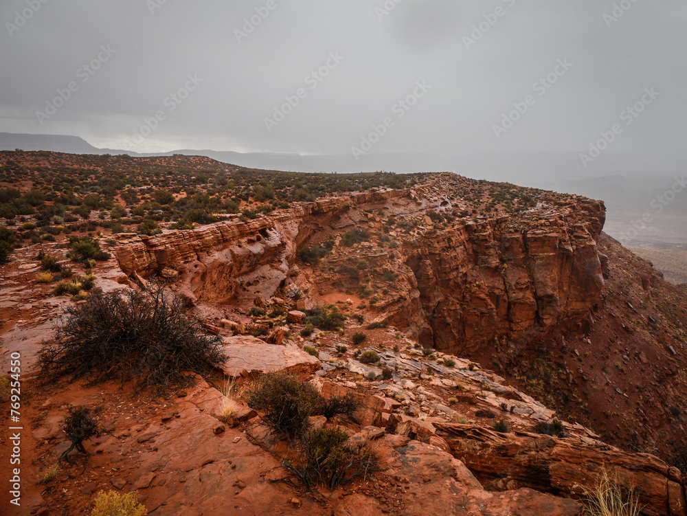 Red sandstone cliffs on desert mesa wet from rain during storm in St ...