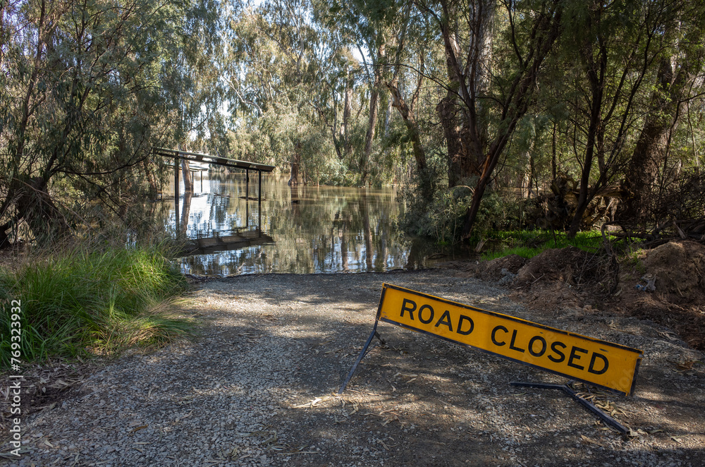 Foto de A 'ROAD CLOSED' sign is placed on a submerged footpath along ...