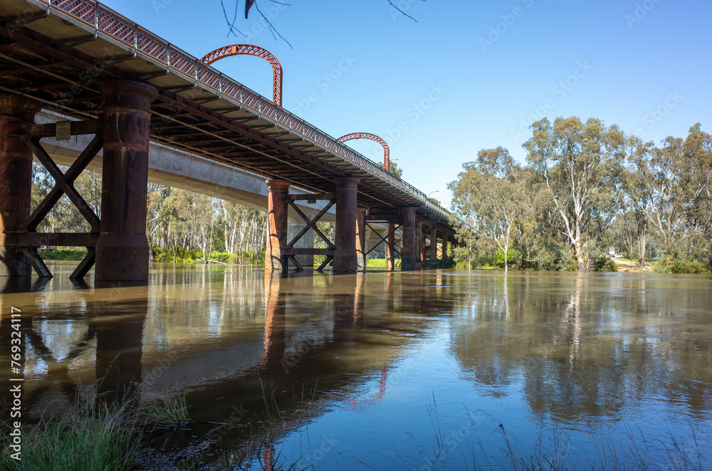 The historic Echuca-moama Road Rail Bridge over the calm waters of the Murray River. It's ...
