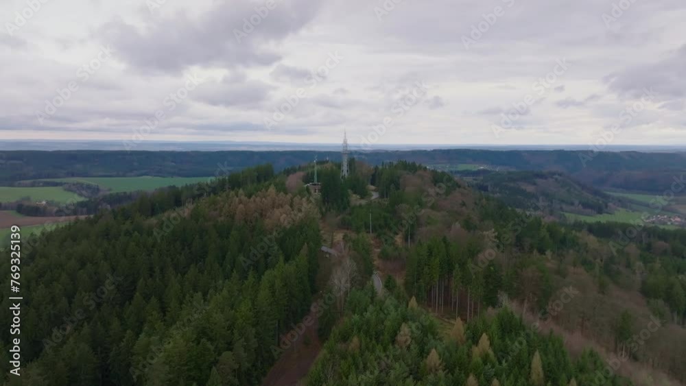 Hill covered with trees and forest on which stands a high iron lookout ...