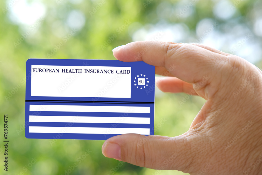 European health insurance card in hand on natural green background ...
