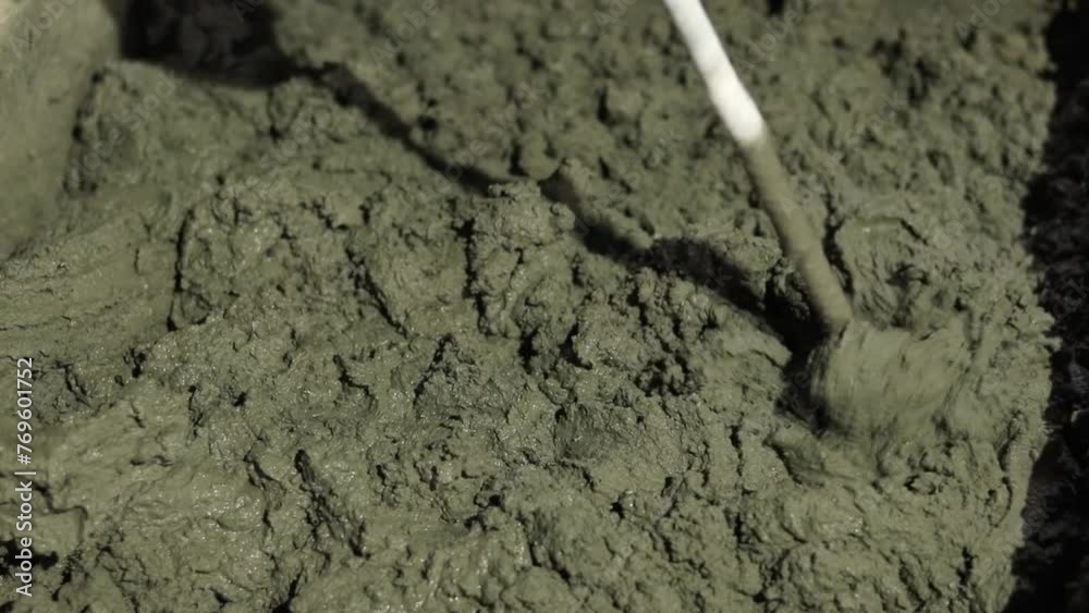 Cement plaster, mortar. Stirring cement mortar with a hammer drill ...