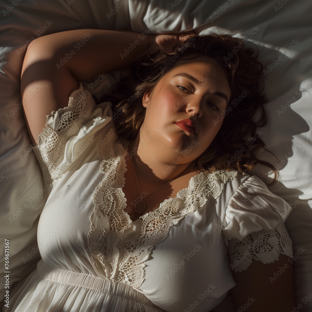 cute caucasian plus size girl lying on the bed. Golden hour lighting ...