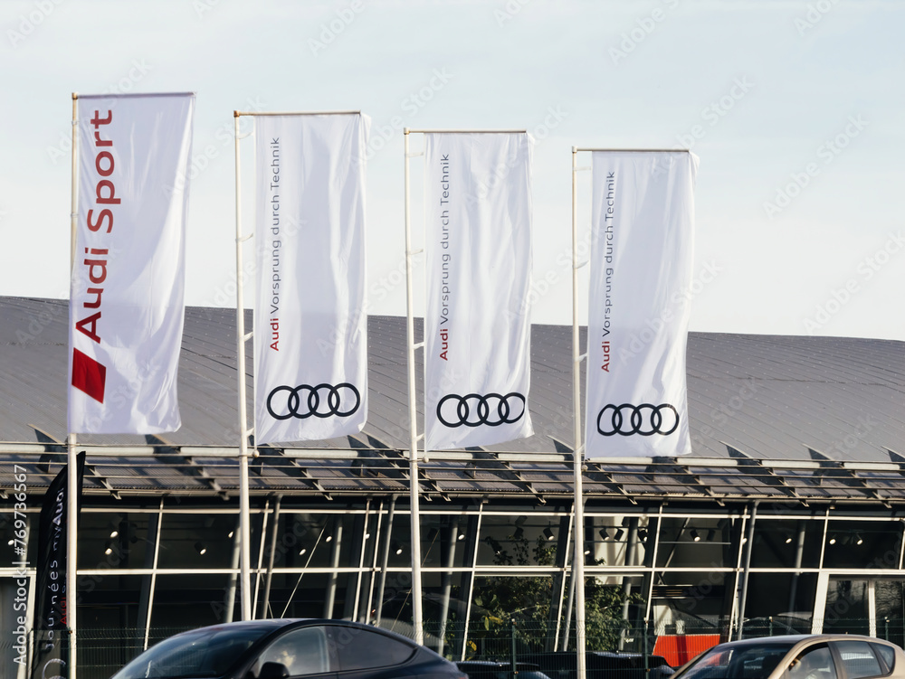 Strasbourg, France - Mar 20, 2024: Audi Sport flags flutter near a car ...