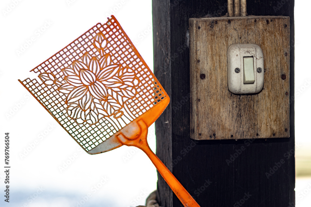 An old fly swatter tied to a beam with a light switch in the yard Stock ...
