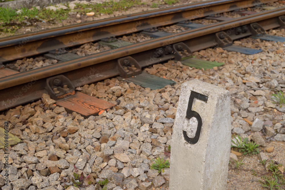 Kilometer marker next to a railway with the boards painted in different ...