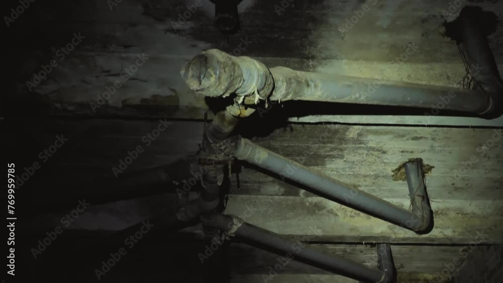 The ceiling of an abandoned building with scary pipes. The light of a ...