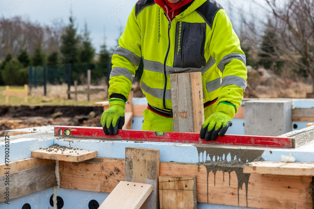 Construction Worker Using Level on Insulated Concrete Forms at Building ...