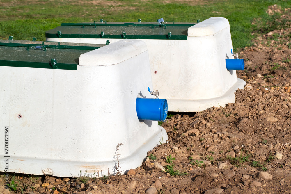 construction workers install pipes and valves for irrigation in fields ...