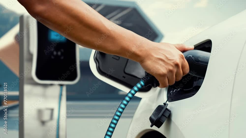 Man insert smart EV charger to electric car and recharging from EV ...