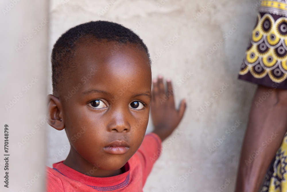 portrait african child sited on the porch in front of the house ...