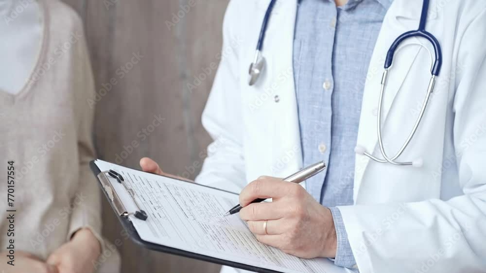 Doctor and patient. Close-up of a doctor's hand taking notes on a ...