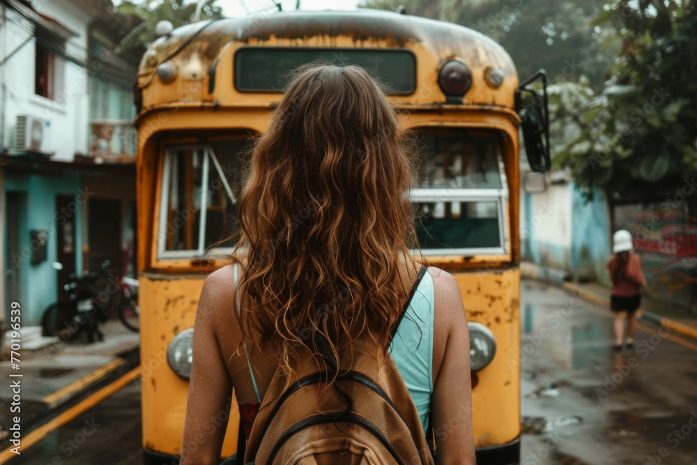 Young woman facing a vintage yellow bus - A young woman with flowing ...