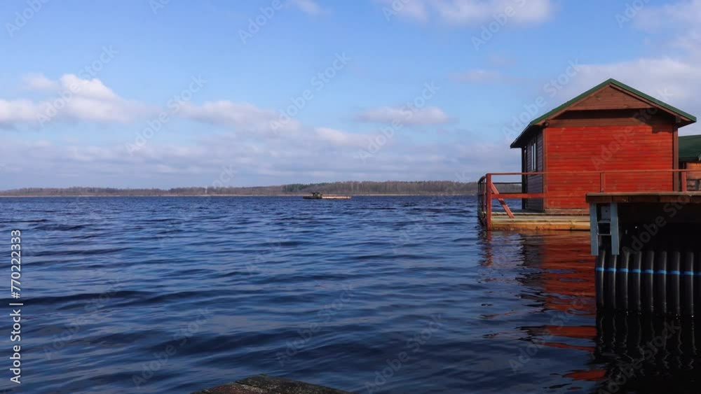 Vidéo Stock Small camping wooden cabin on raft float on calm blue water ...