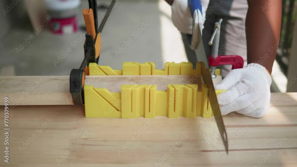Carpenter sawing wood plank with hand saw. A man doing detailed wood ...