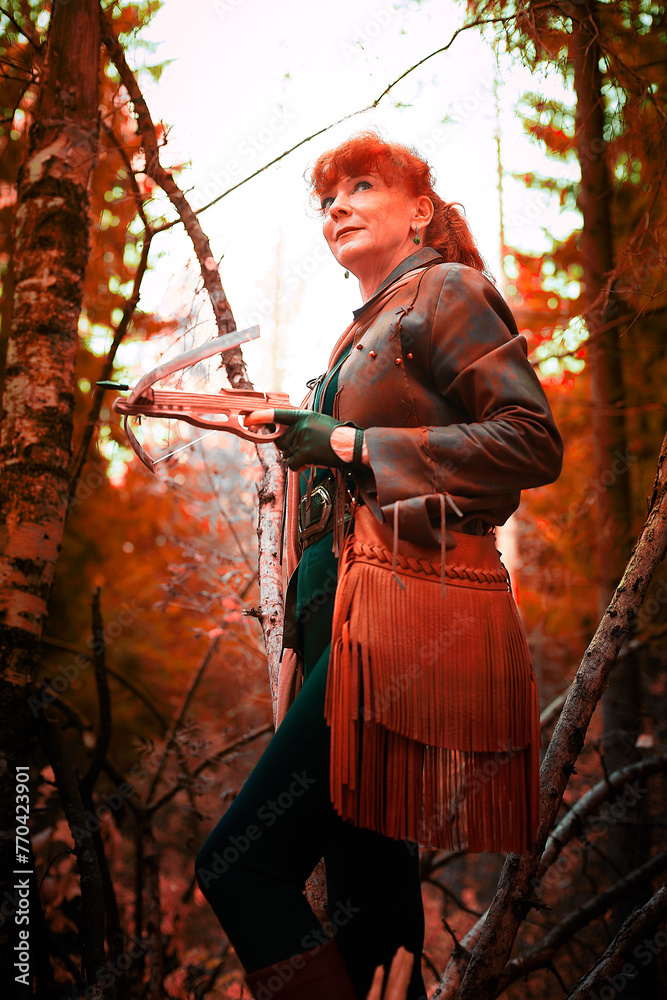 Mature model portraying a royal huntress with red curve hair is hunting ...