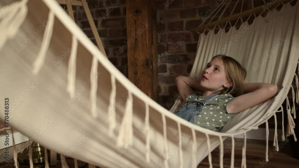 Preteen girl child lying in hammock and singing song at home. Pretty fe ...