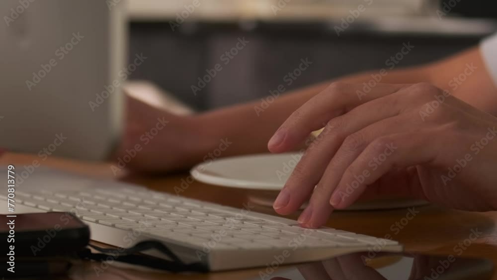 Close-up of woman hands behind computer keyboard and next to plate of ...