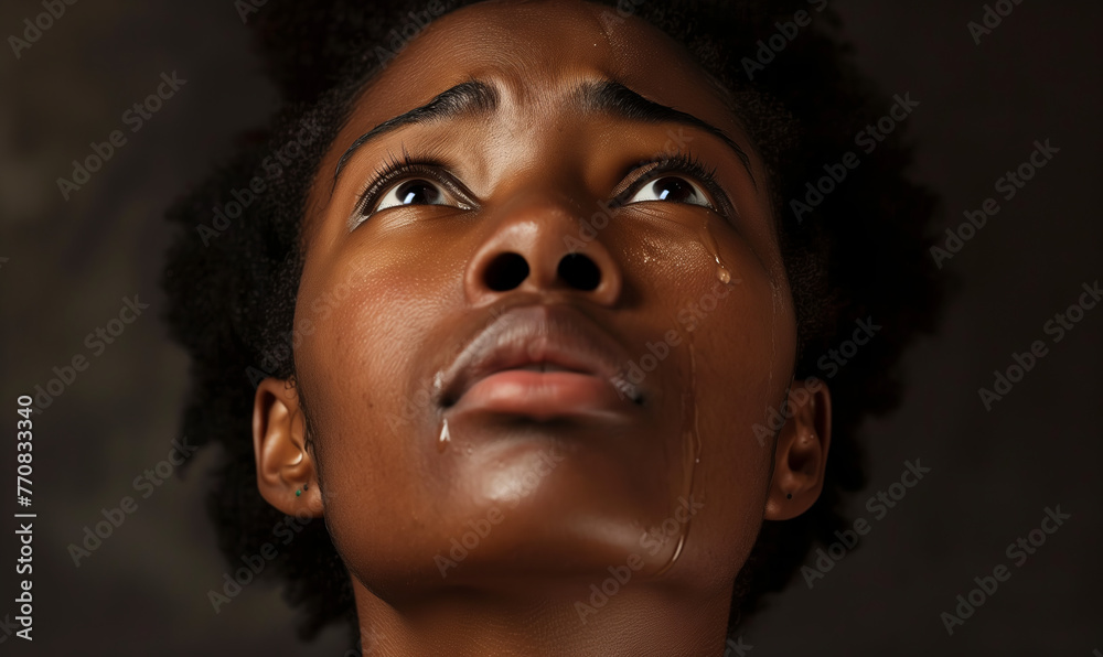 Young black woman looking up praying to God with tears in eyes, being ...