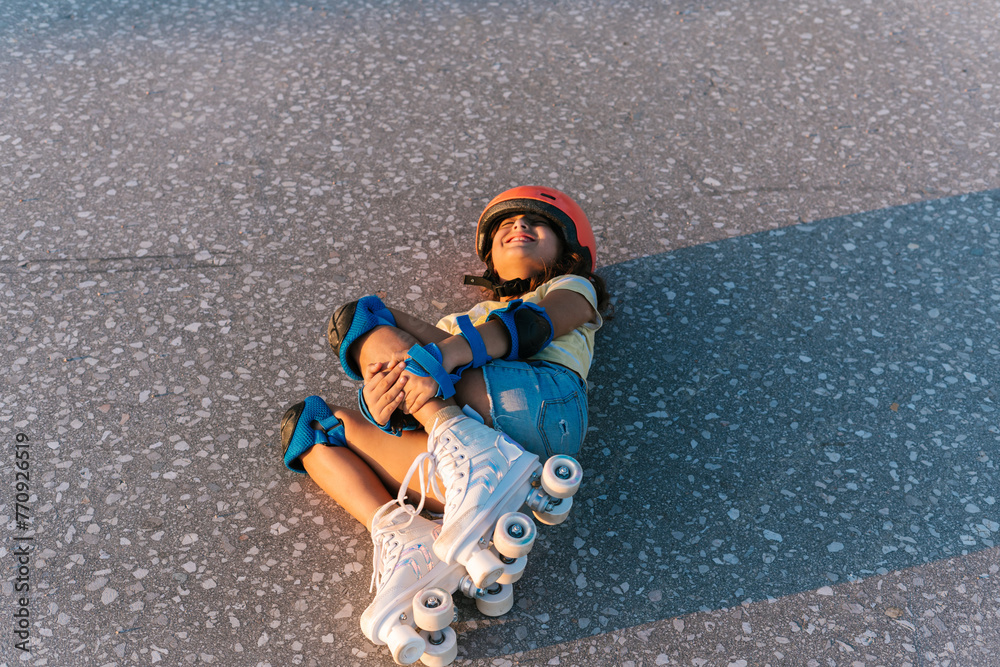 Girl in roller skates lying and crying after fall Stock Photo | Adobe Stock