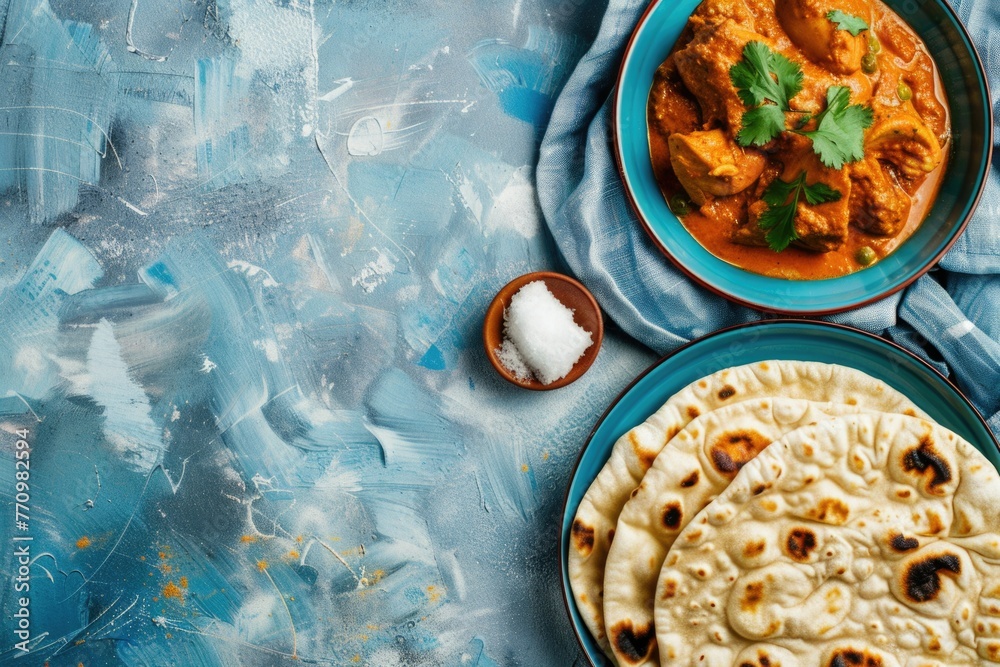 Butter chicken and chapatis on a bright blue background. curry, masala ...