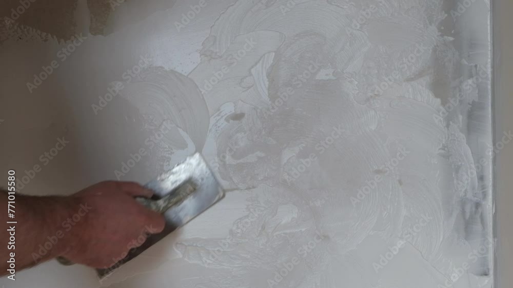 Applying decorative putty. White abstract texture of surface covered ...