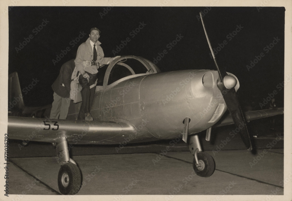 1956. Aviator posing for a portrait while on the wing of an airplane ...