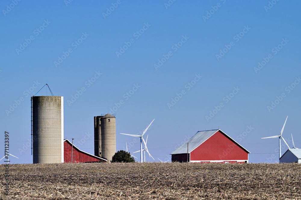Barns, silos and wind turbines make up an array of structures that rise ...
