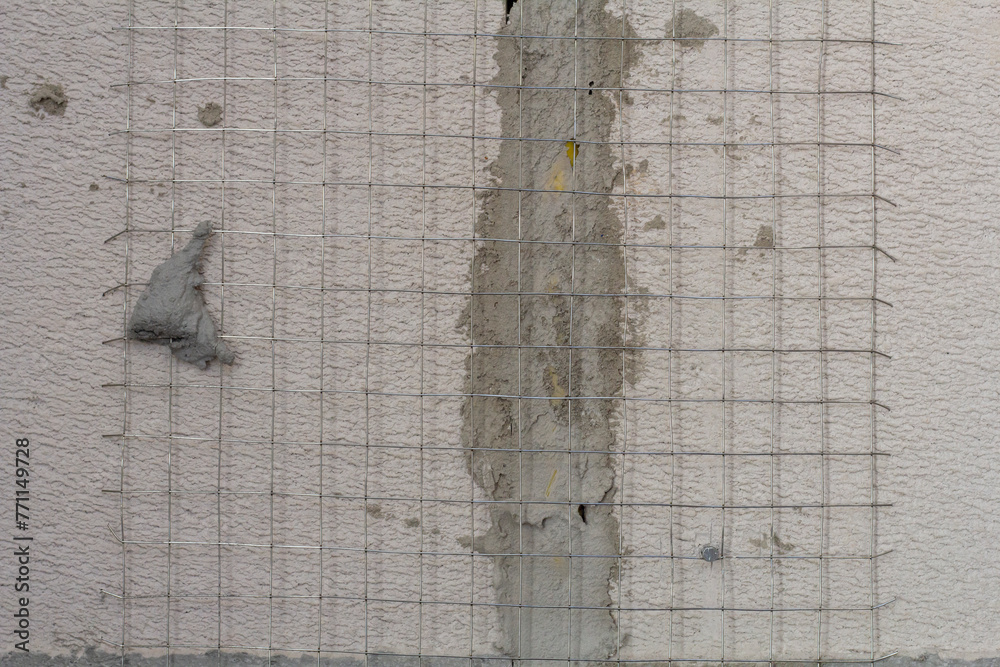 Plaster the wall with cement reinforcing wire mesh in construction site ...