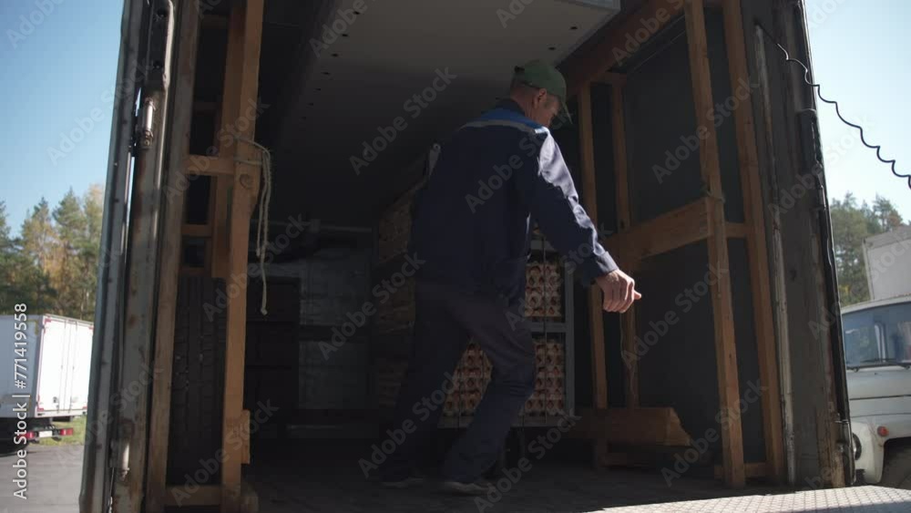 Factory Worker unloading the huge truck. Worker unloading the heavy ...