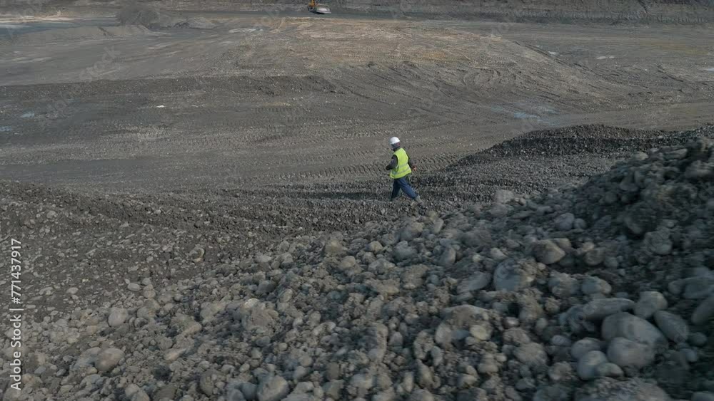 Surveyor walking at the huge industrial mineral open-pit ore mine ...