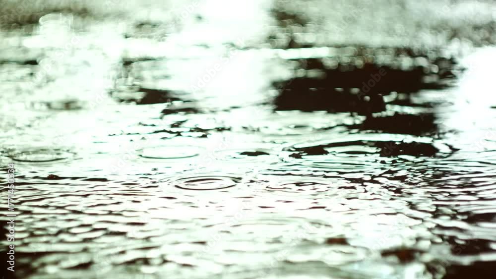 The surface of water during rain with the reflection of bright white ...