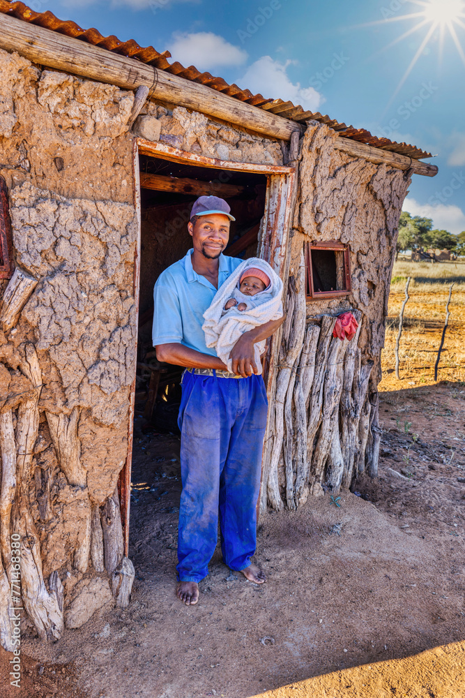 african father with one baby in the village in front of the shack, mud ...