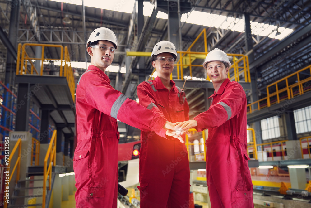 Three male technicians wearing helmet uniforms holding hands join hand ...