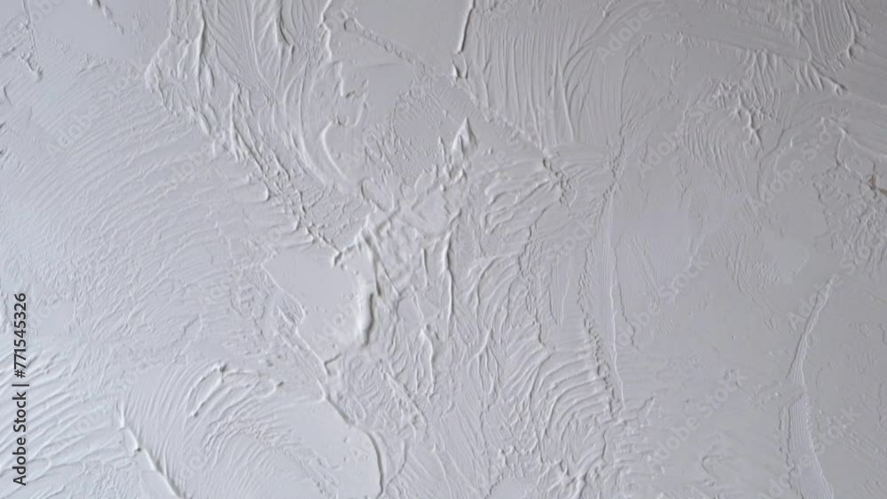 Applying decorative putty. White abstract texture of surface covered ...
