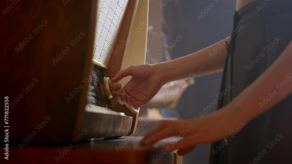 Close up unrecognizable girl approaches a vintage radio and turns the ...