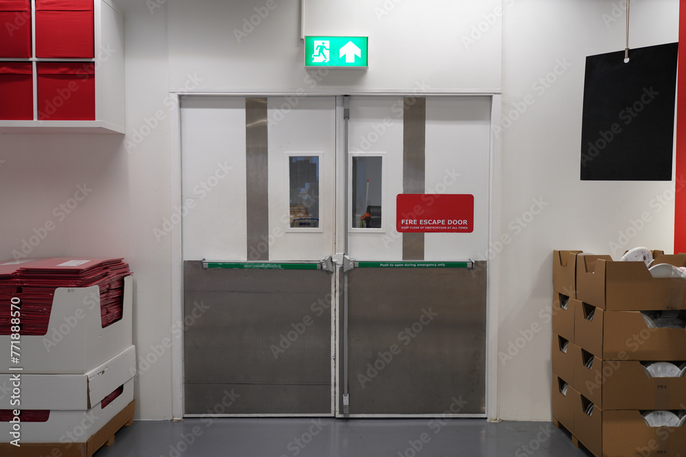 Fire extinguishers and fire escape door in building Stock Photo | Adobe ...