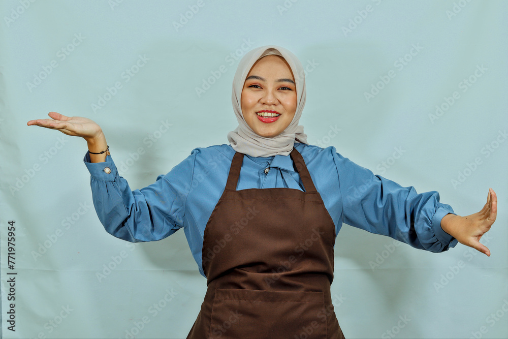 young Asian Muslim woman wearing hijab and brown apron dancing isolated ...