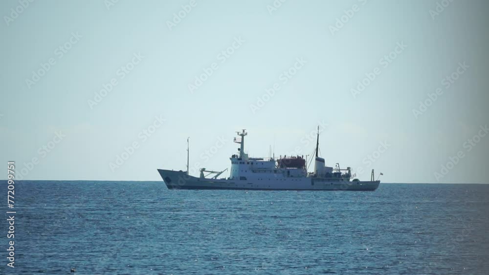Fishing boat trawler catches fish while sailing on sea. A commercial ...