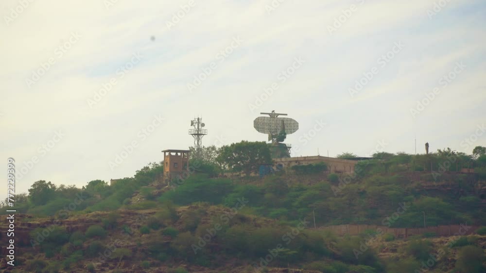 Rotating military radar dish operations center on top of a mountain ...