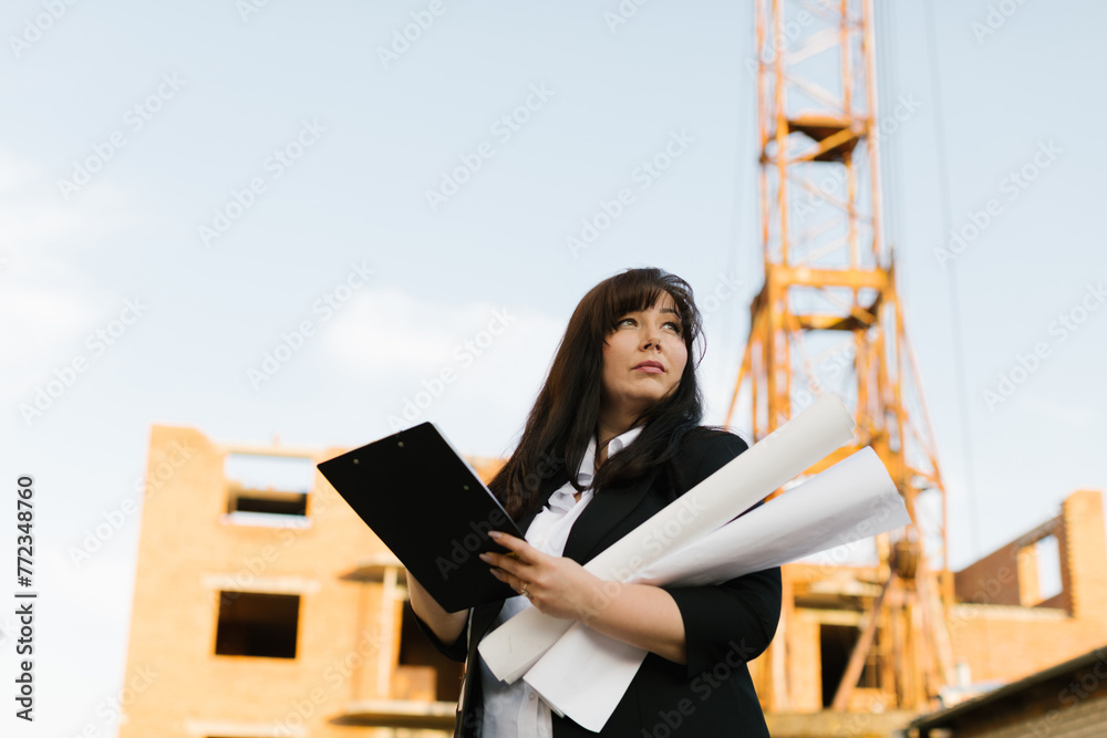 Plus size woman engineer in a white shirt and black jacket is holding ...