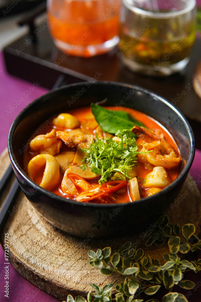 tom yum, soup, in a black bowl, top view, shrimp, mushroom, squid, red ...