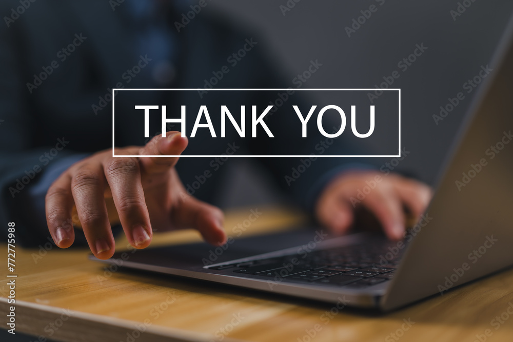 businessman using a laptop sends the message thank you on a display ...